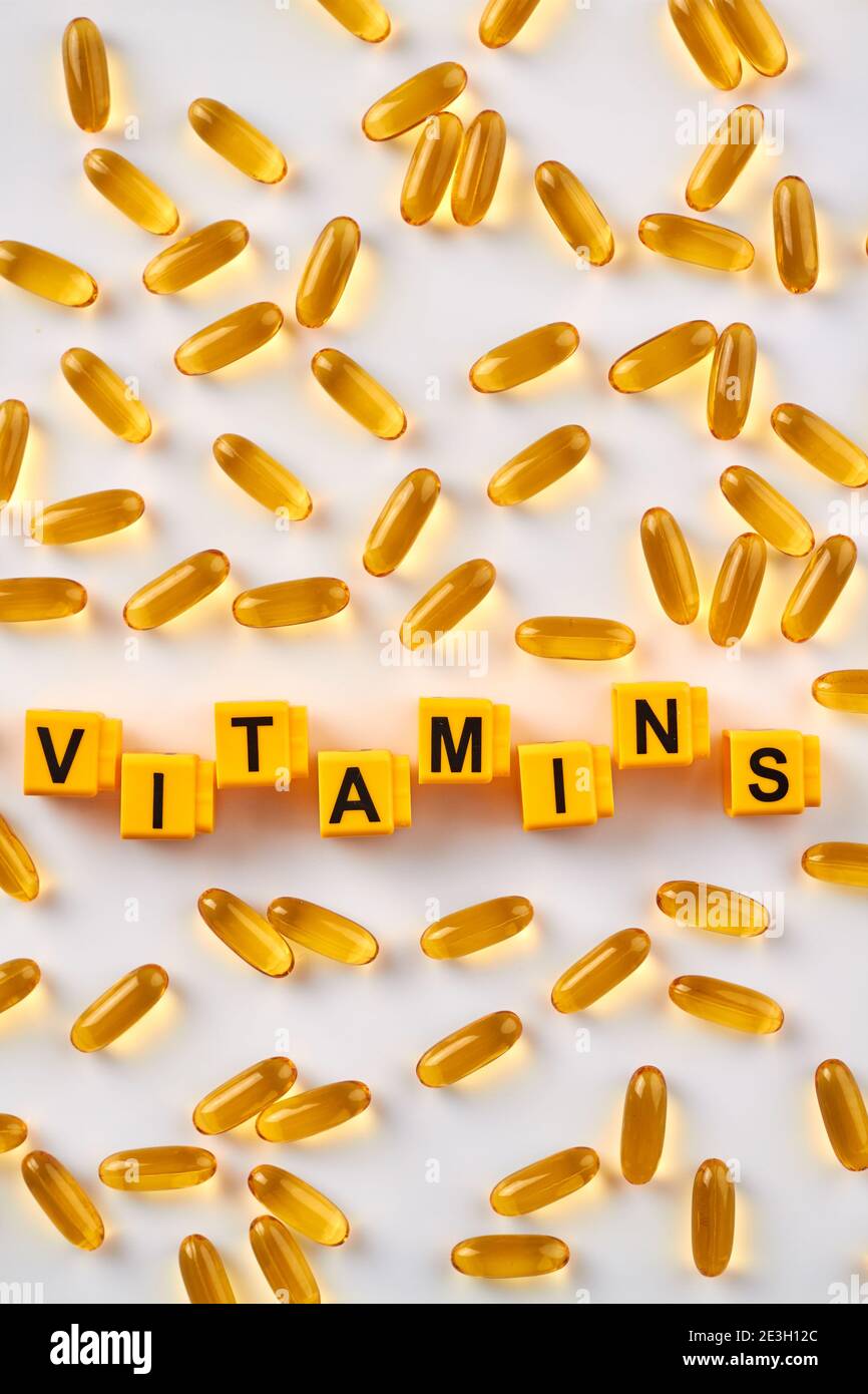 Many yellow capsules on white background Stock Photo - Alamy