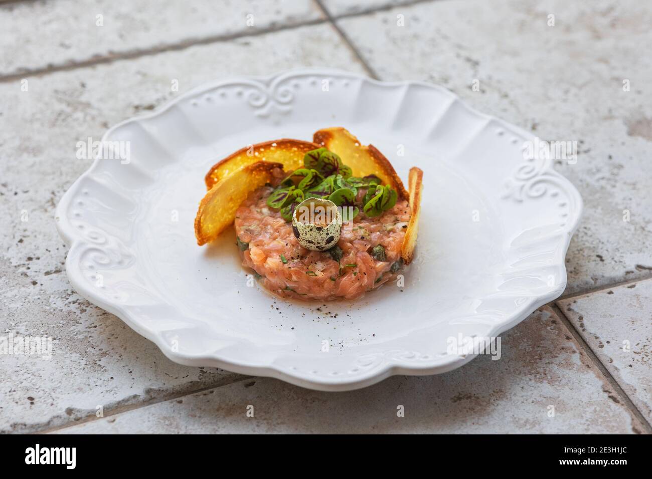 plate of salmon tartare with raw egg and toasted bread slices Stock ...