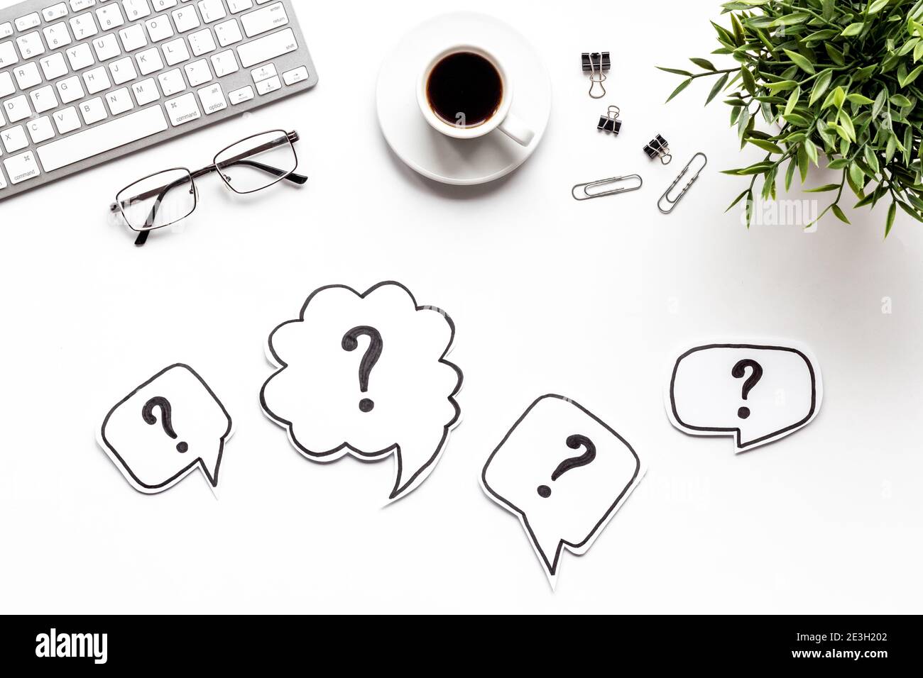 Question marks on office dest - FAQ concept. Top view Stock Photo - Alamy