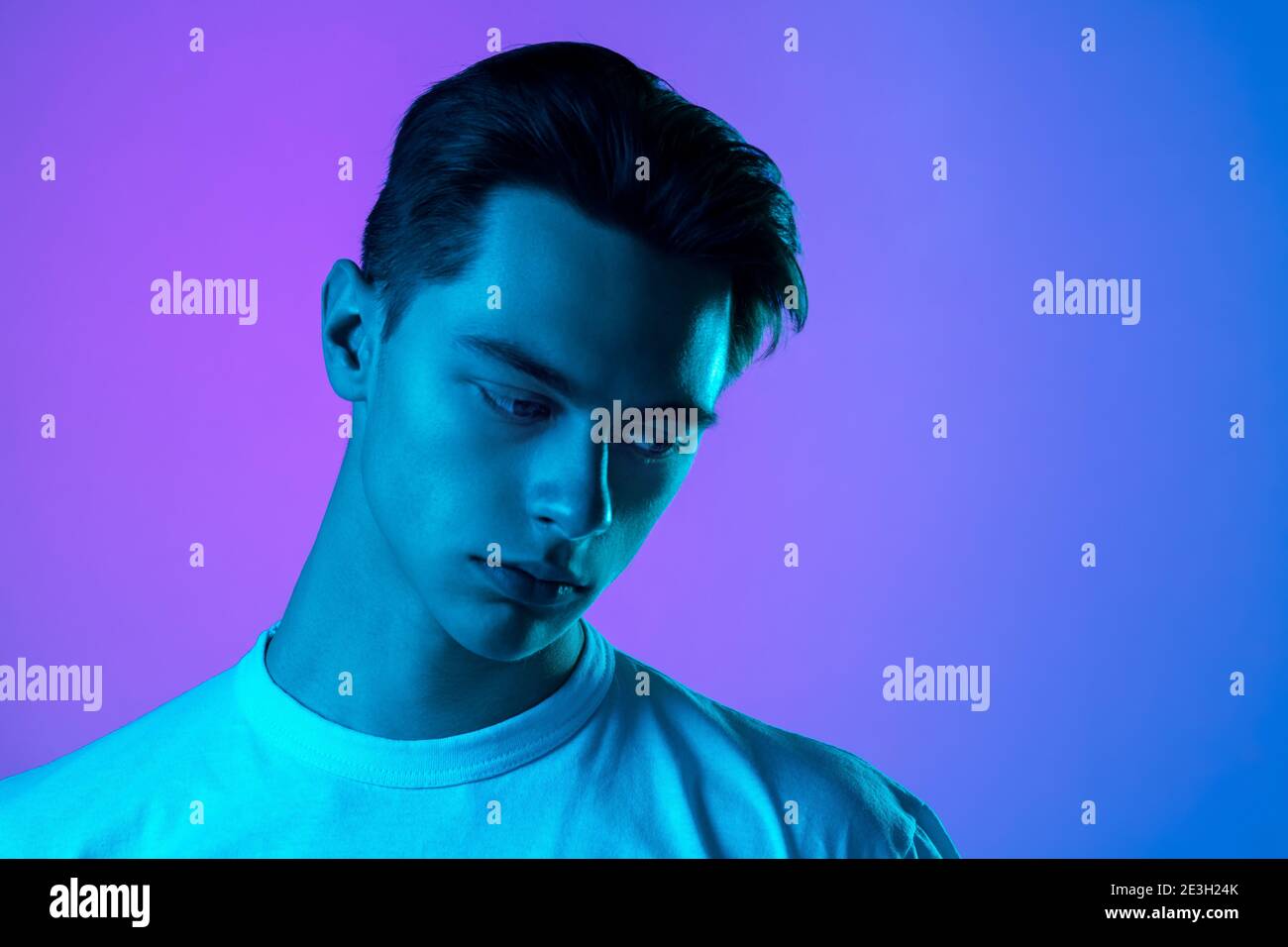 Sadness. Handsome caucasian man's portrait isolated on purple studio ...