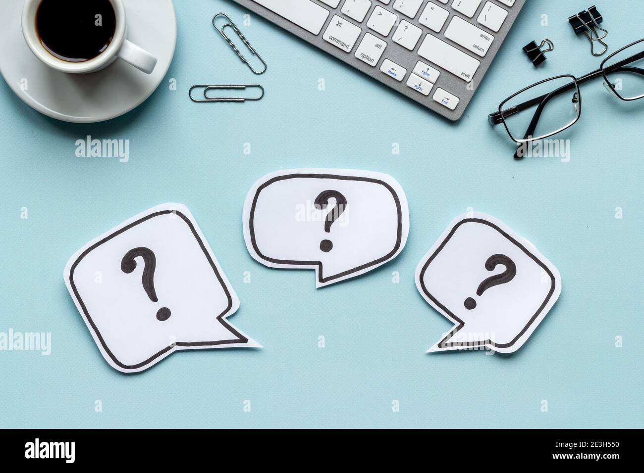 Question marks on office dest - FAQ concept. Top view Stock Photo - Alamy