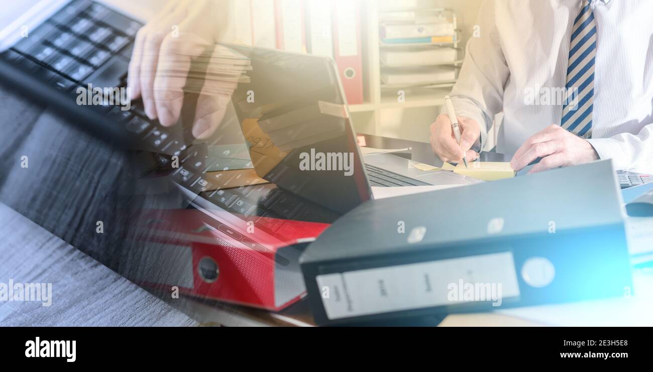 Businessman working at an untidy and cluttered desk; multiple exposure ...