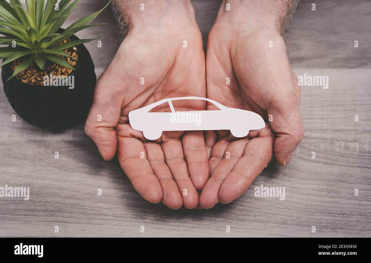 Hands protecting a car; symbol of car insurance Stock Photo - Alamy