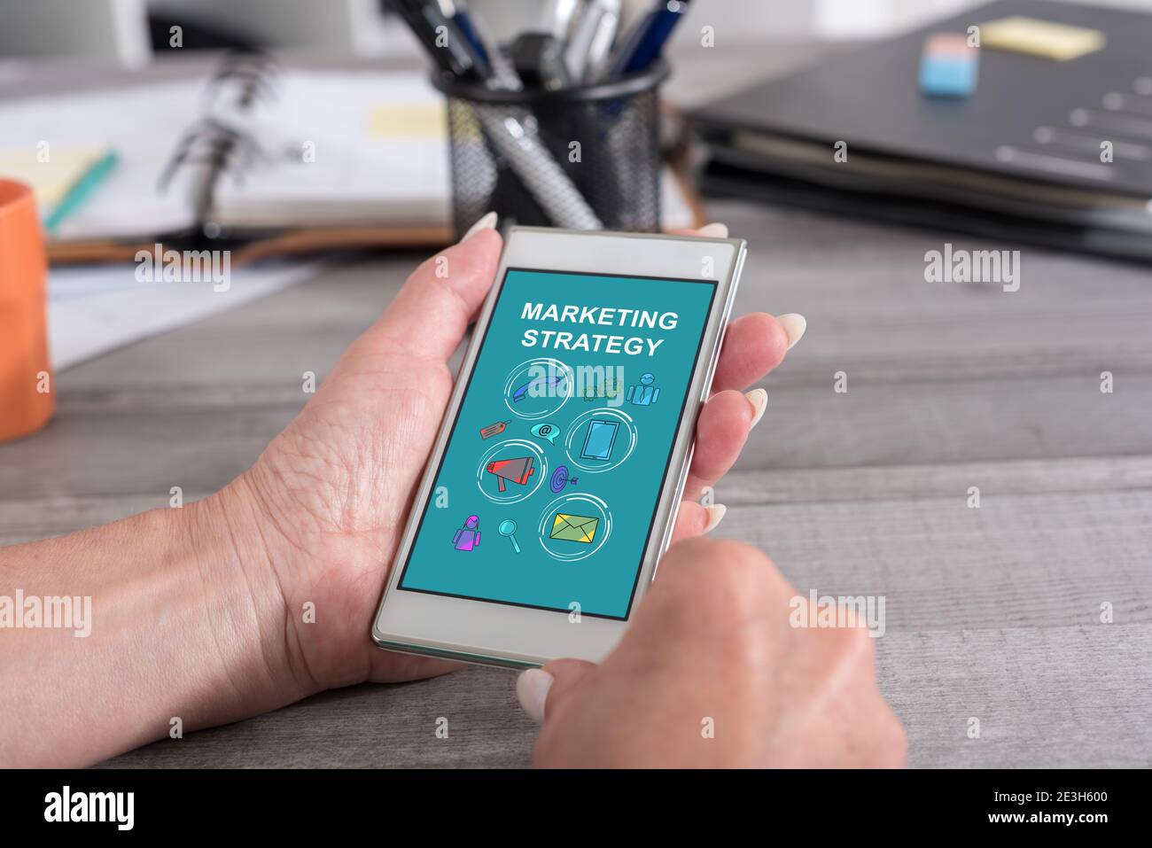 Female hand holding a smartphone with marketing strategy concept Stock ...