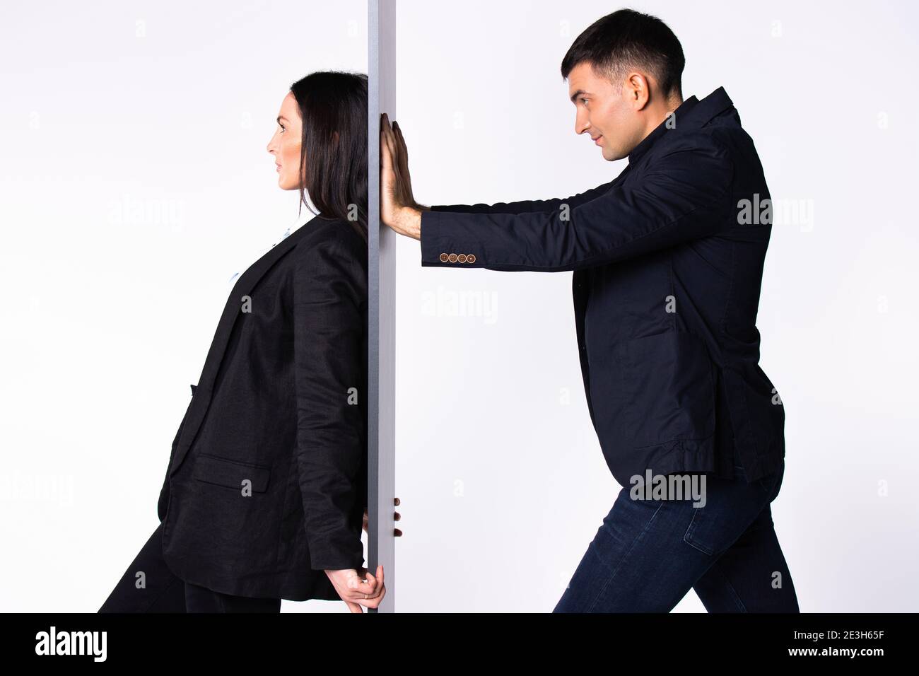 A self-confident business woman is leaning her back against the wall ...