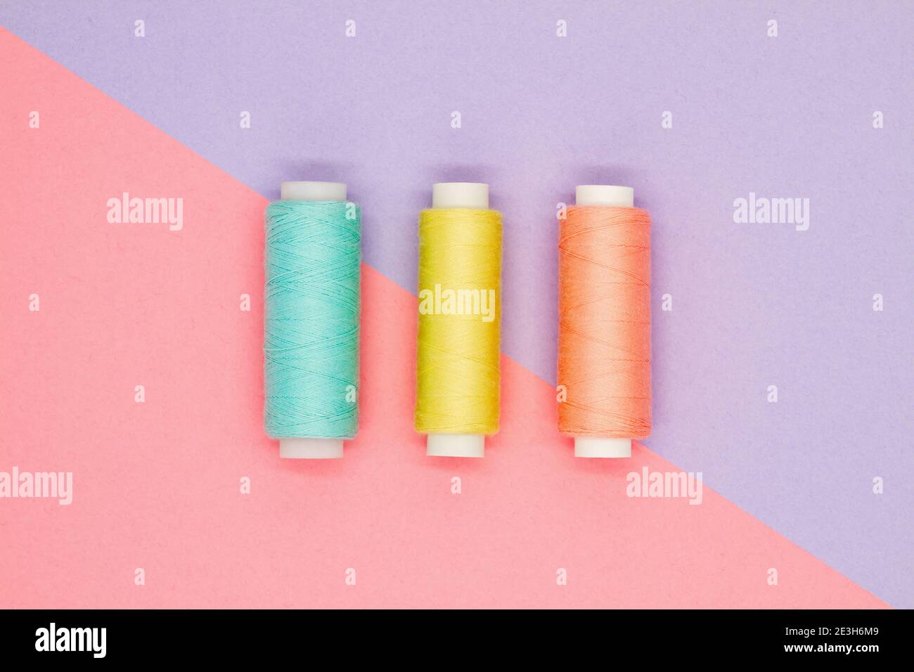 Top view of multi-colored sewing reels on a colored background. Hobby ...