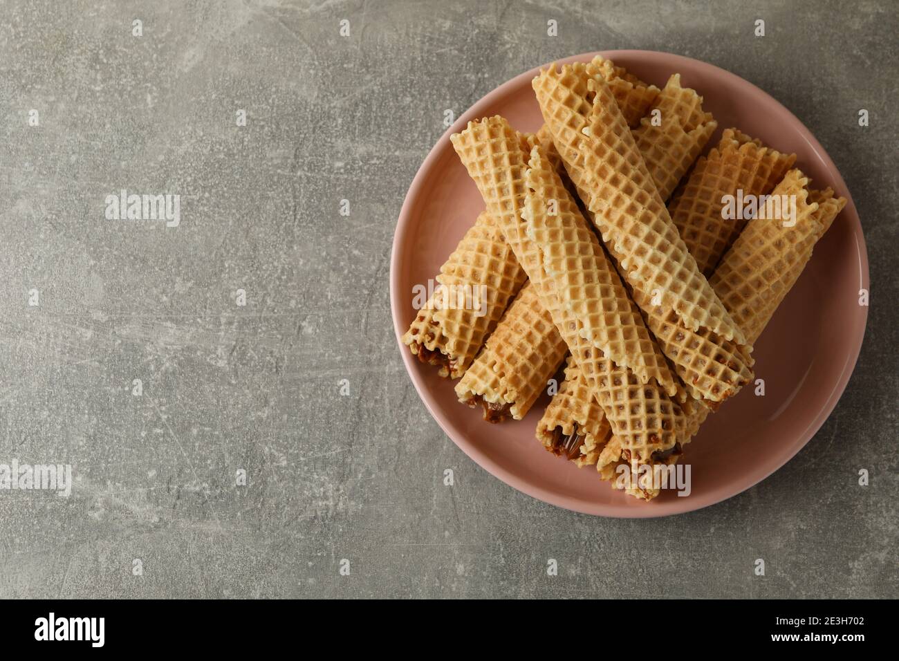 Plate with wafer rolls with condensed milk on gray background Stock ...