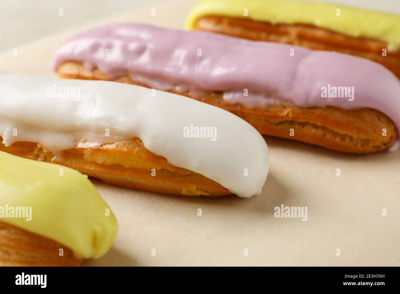 Baking paper with tasty eclairs with custard Stock Photo - Alamy