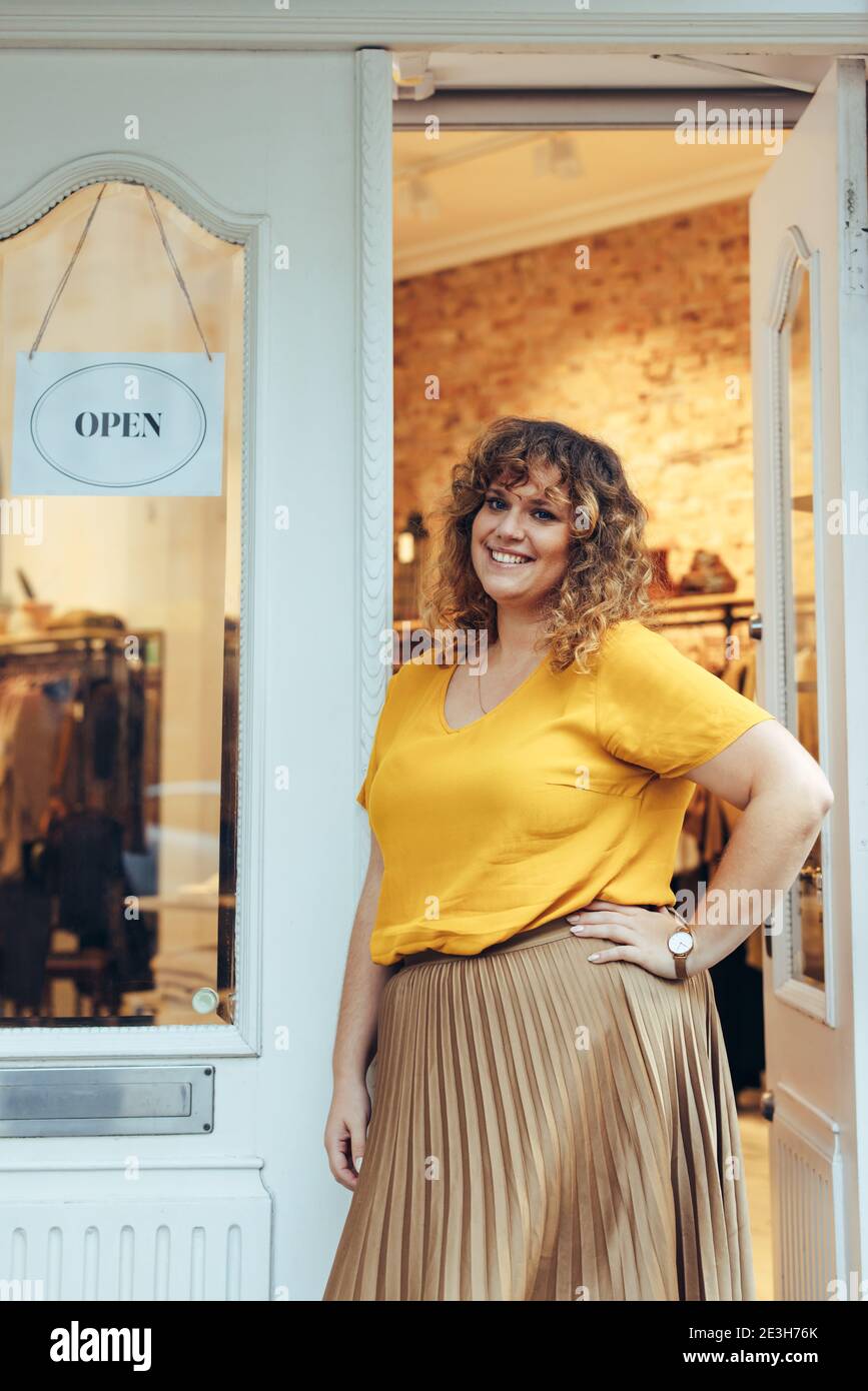 Clothing shop owner looking at camera and smiling. Successful female ...
