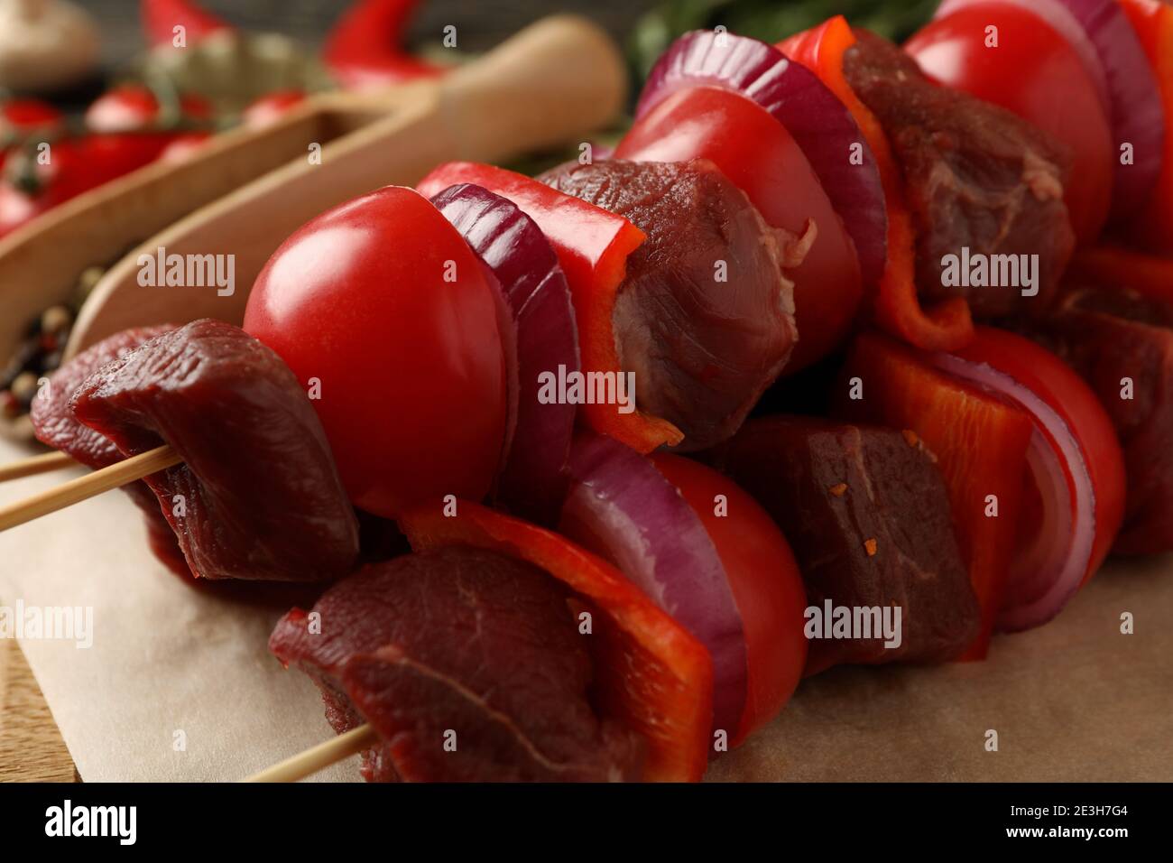 Tasty raw shish kebab on baking paper on wooden board, close up Stock ...