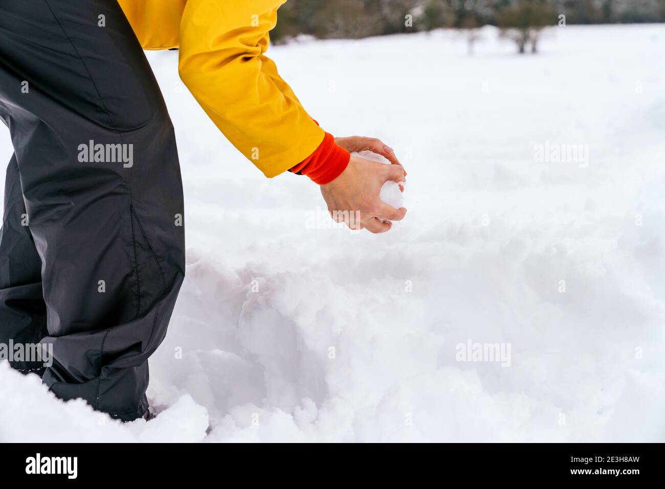 photograph in the snow of some hands making a snowball with a yellow ...