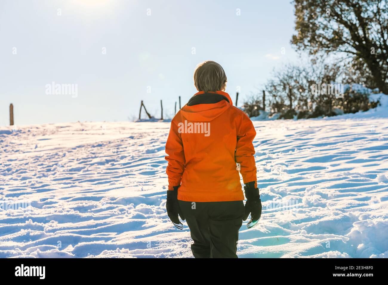 back view of a woman walking in the snow against the light on a ...
