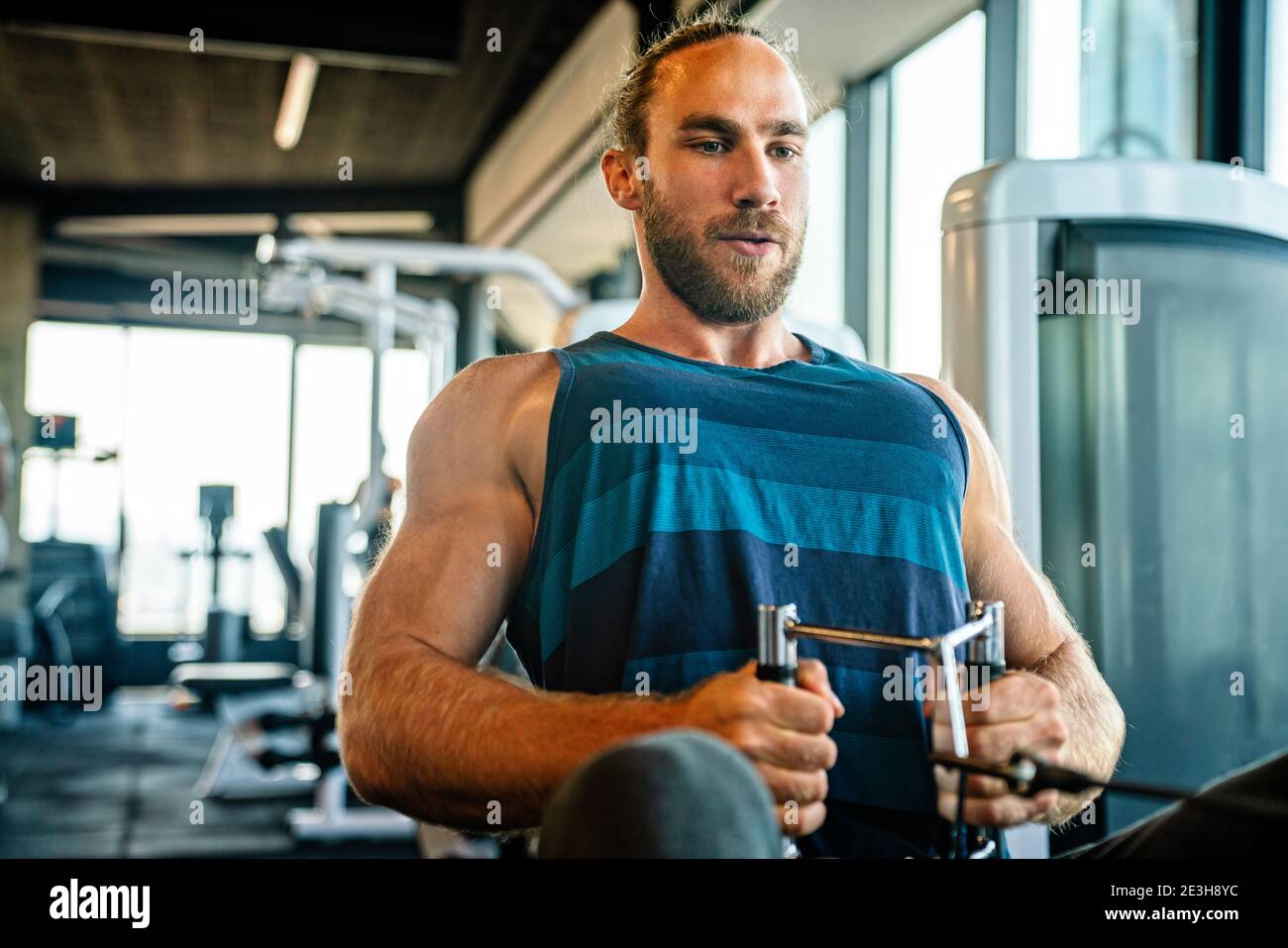 Muscular man working out in gym doing exercises to stay healthy Stock ...