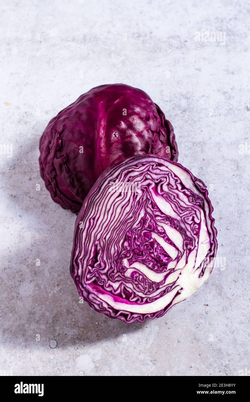 Raw red cabbage sliced in half on a grey backdrop Stock Photo - Alamy