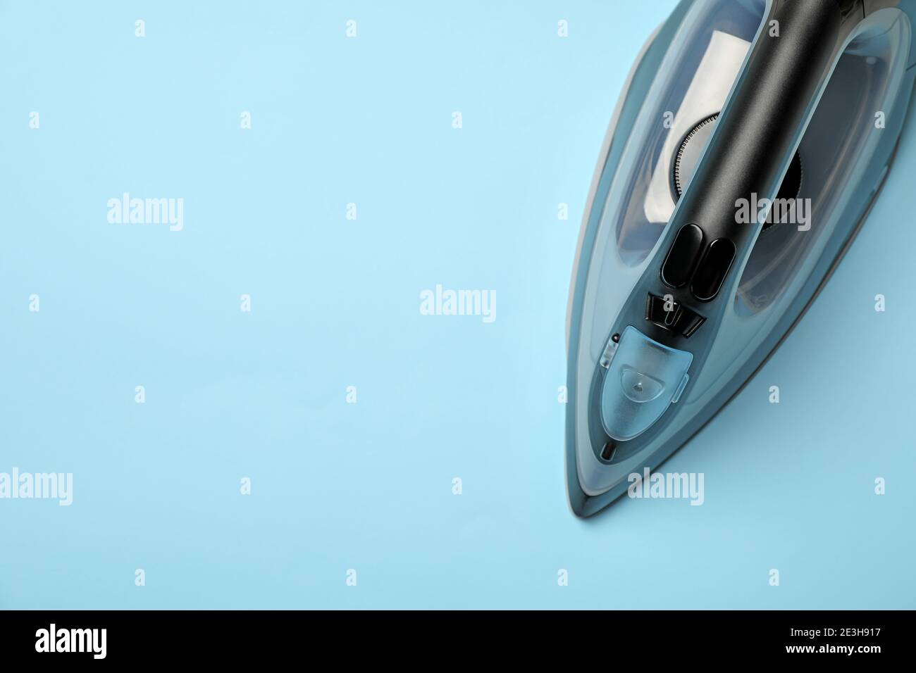 Modern iron on blue background, space for text Stock Photo - Alamy