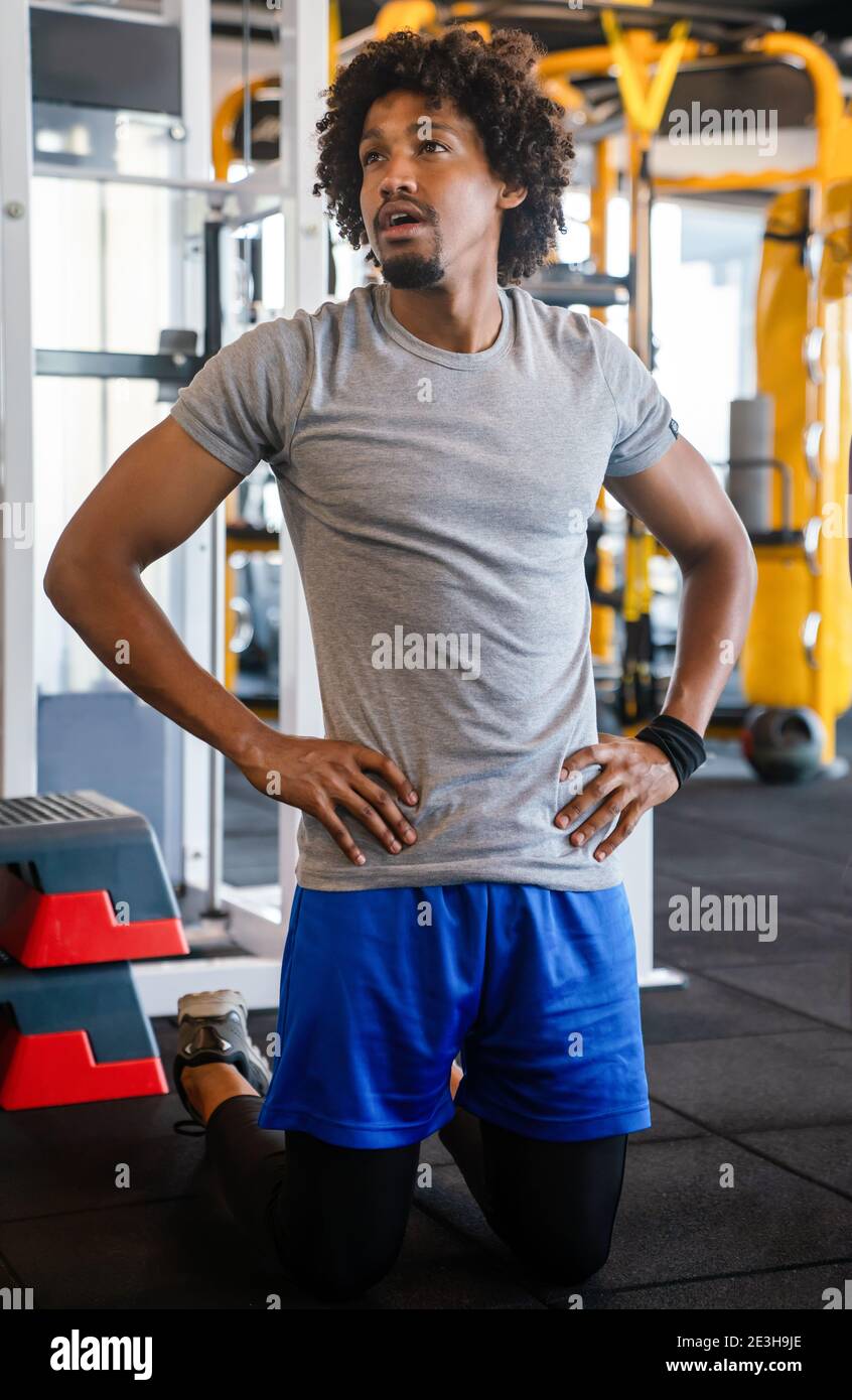 Fit man exercising at the gym on a machine Stock Photo - Alamy