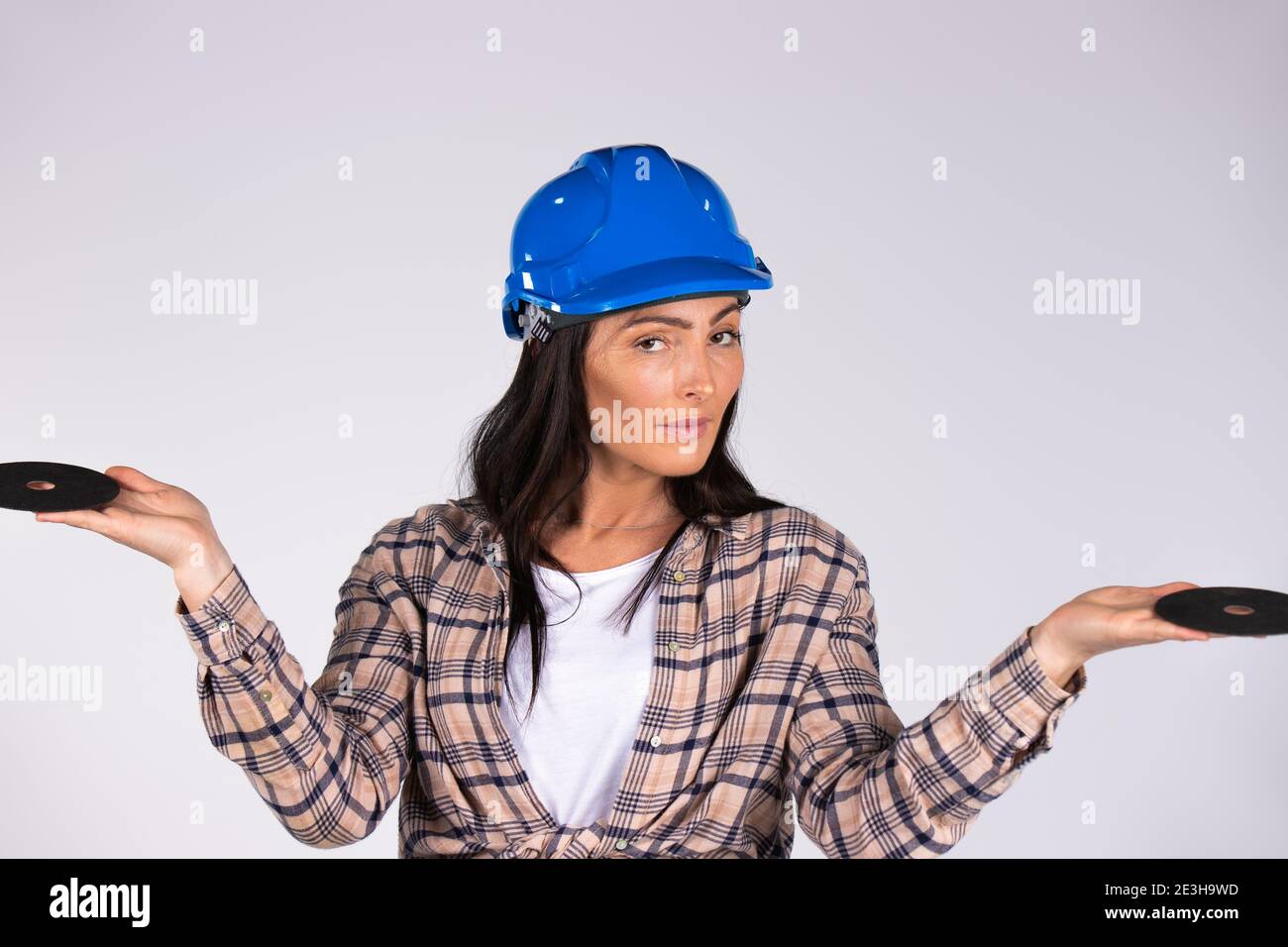 A serious woman in a blue cap looks at the camera and holds her discs ...