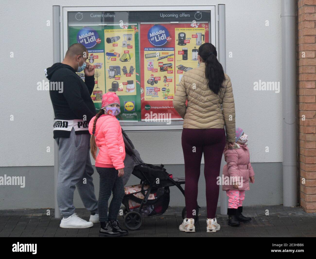 A family lining up outside of a shop during the second lockdown in ...