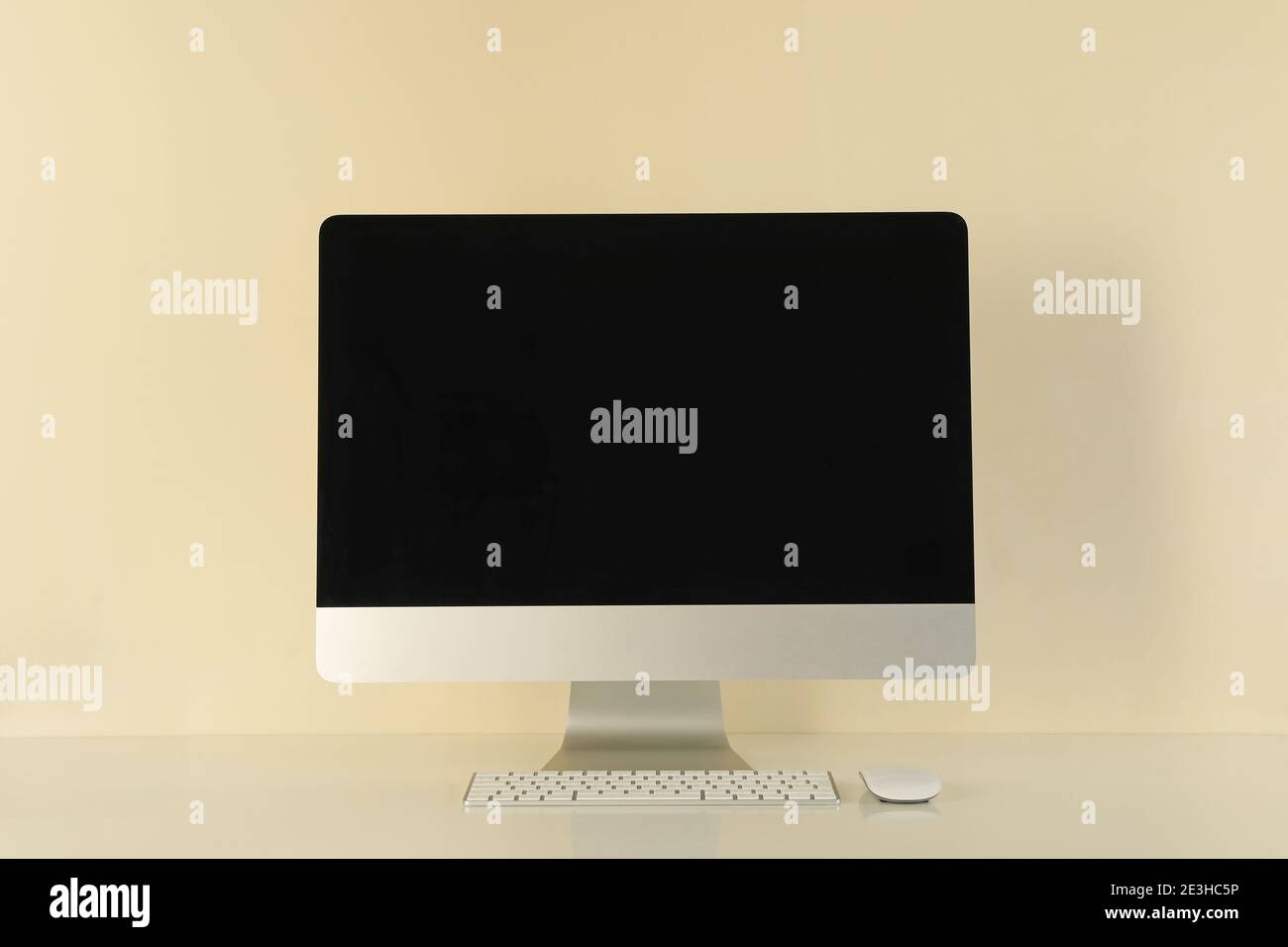 Blank screen desktop computer against beige background Stock Photo - Alamy