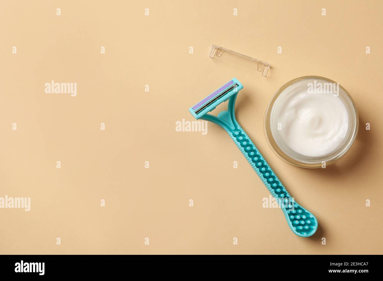 Razor and cosmetic cream on beige background Stock Photo - Alamy