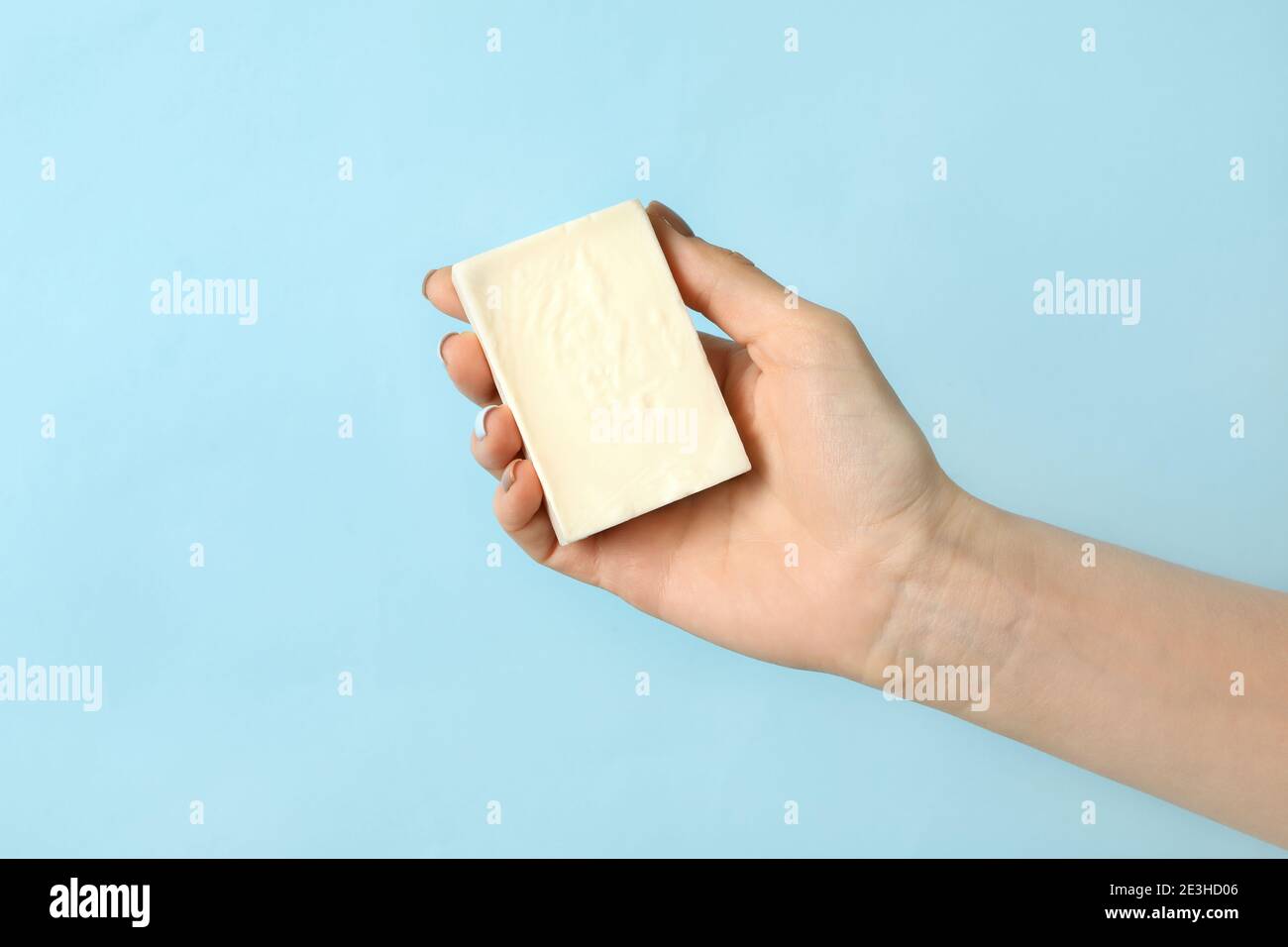 Female hand hold handmade soap on blue background Stock Photo - Alamy