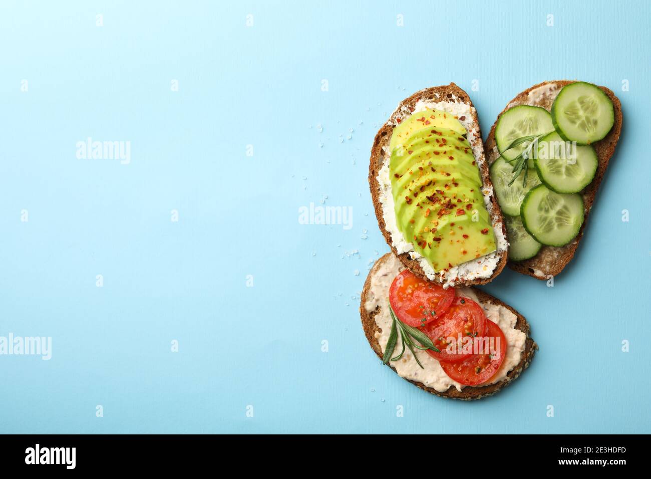 Tasty toasts with different topping on blue background Stock Photo - Alamy