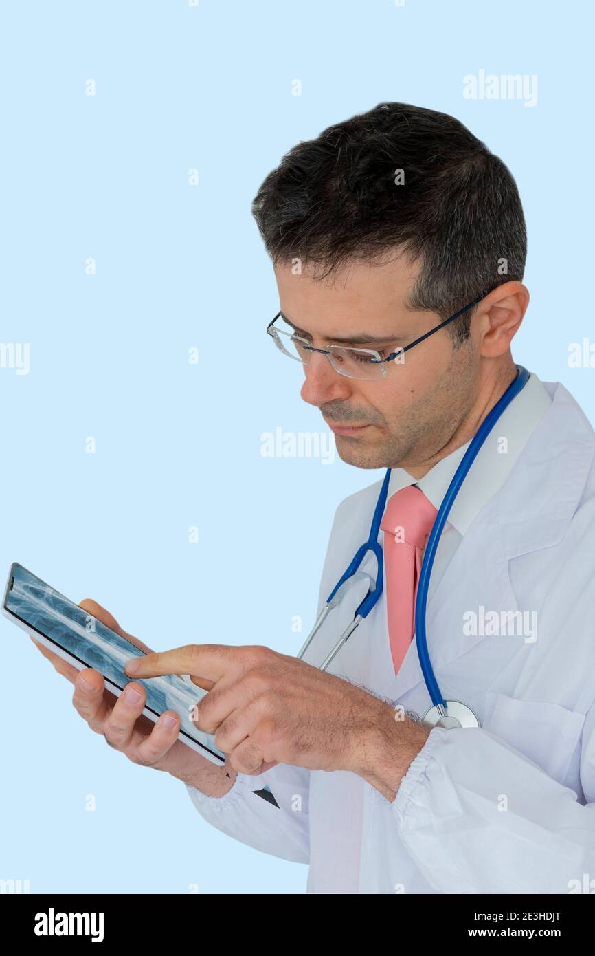 Caucasian doctor of medicine uses a tablet to view a chest x-ray ...