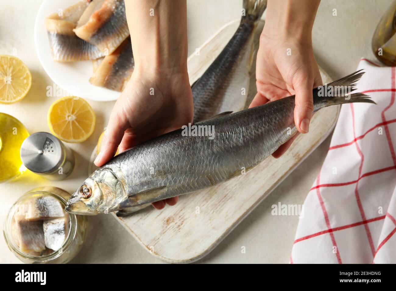 Concept of cooking fish with woman hold fresh herring fish Stock Photo ...