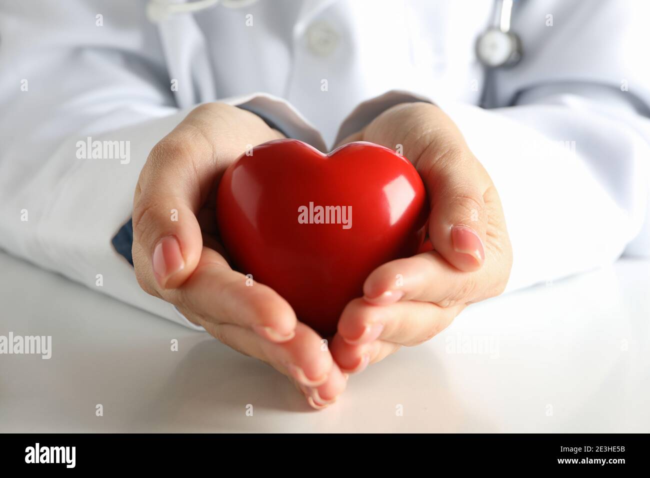 Female doctor holding red heart, close up Stock Photo - Alamy