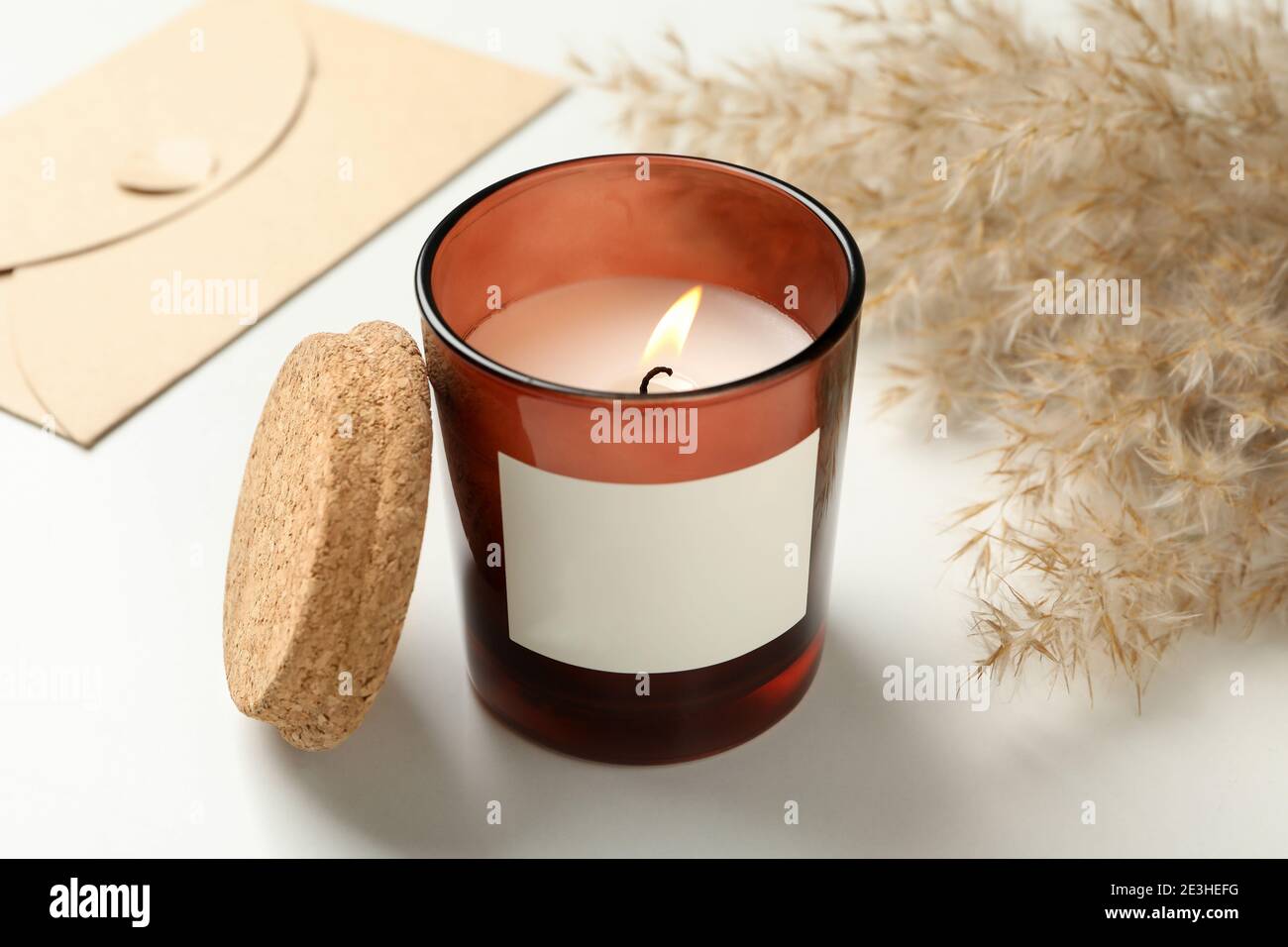 Scented candle, envelope and reed on white background Stock Photo - Alamy