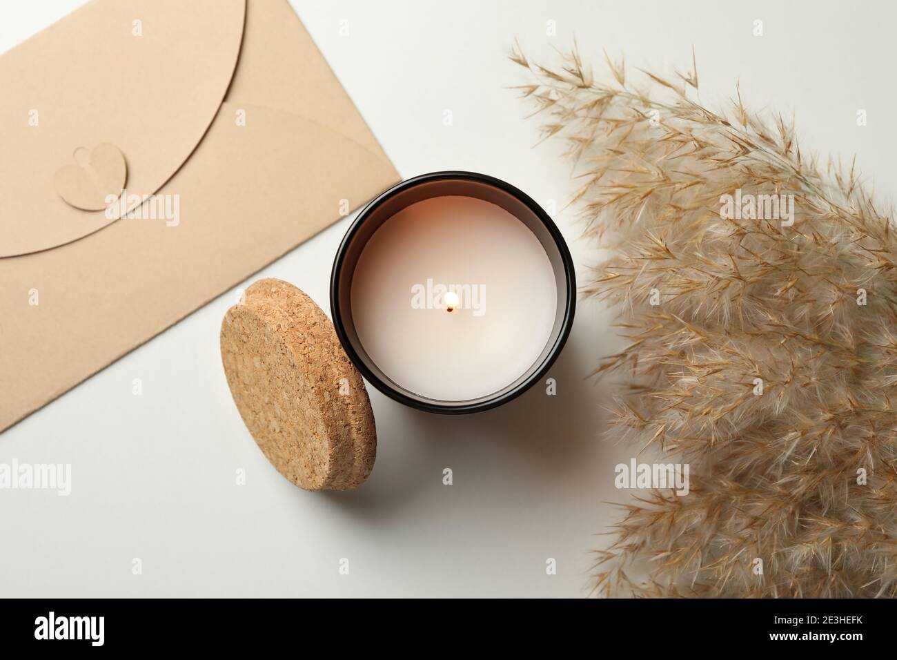 Scented candle, envelope and reed on white background Stock Photo - Alamy