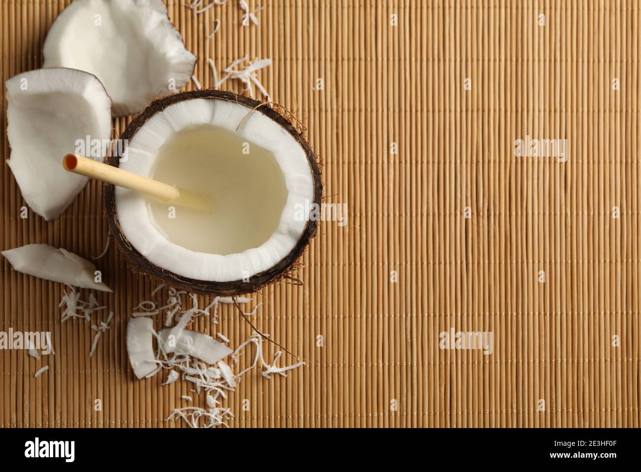Tasty coconut with straw on bamboo background Stock Photo - Alamy