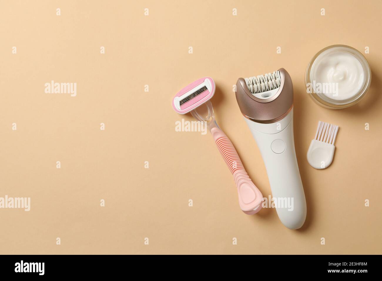 Epilator, razor and cream on beige background Stock Photo - Alamy