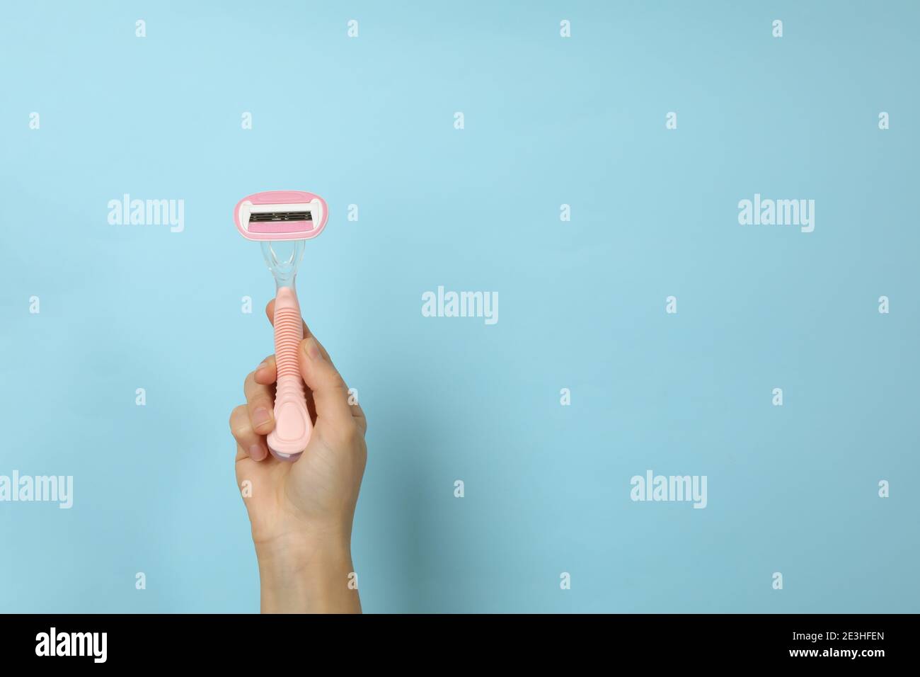 Female hand hold razor on blue background, space for text Stock Photo ...