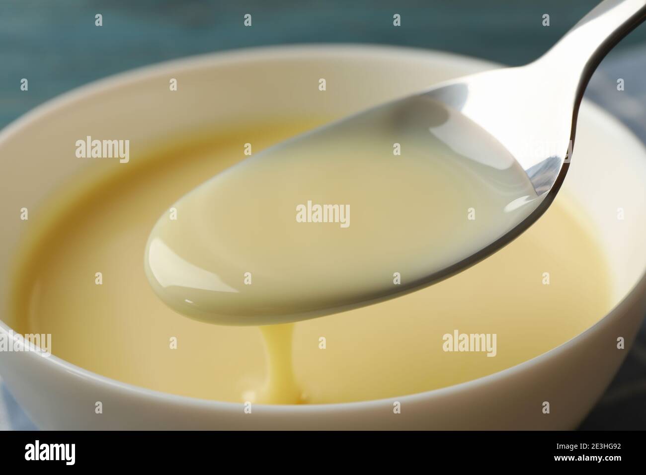 Spoon and bowl with condensed milk, close up Stock Photo - Alamy