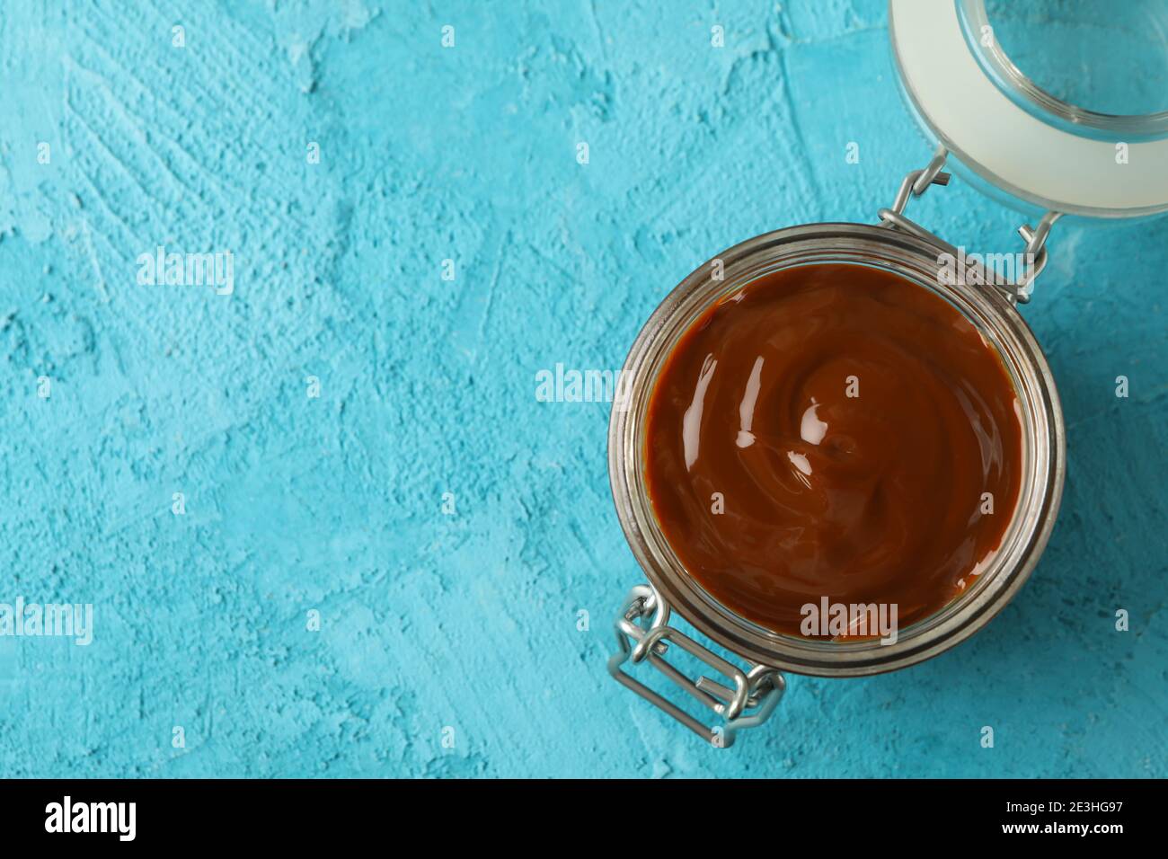 Glass jar with caramel condensed milk on blue background Stock Photo ...