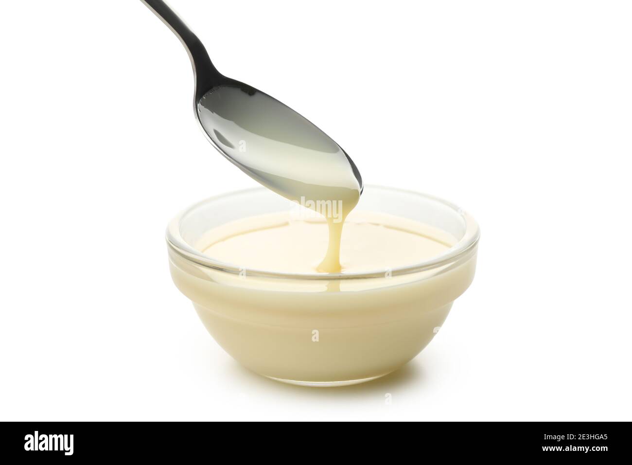 Spoon and bowl with condensed milk isolated on white background Stock ...