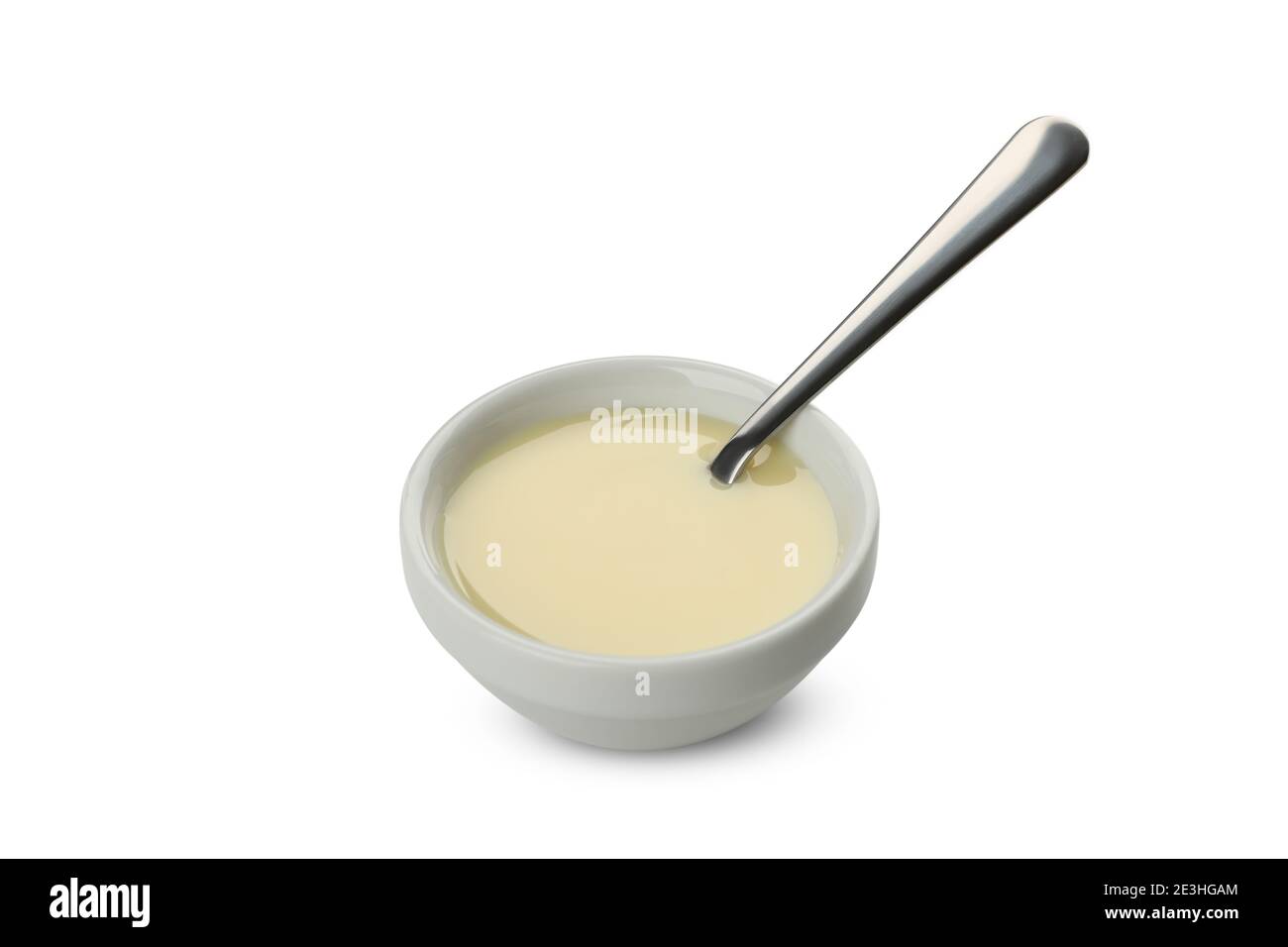 Bowl with condensed milk and spoon isolated on white background Stock ...