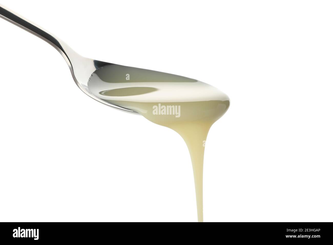 Spoon with dripping condensed milk isolated on white background Stock ...