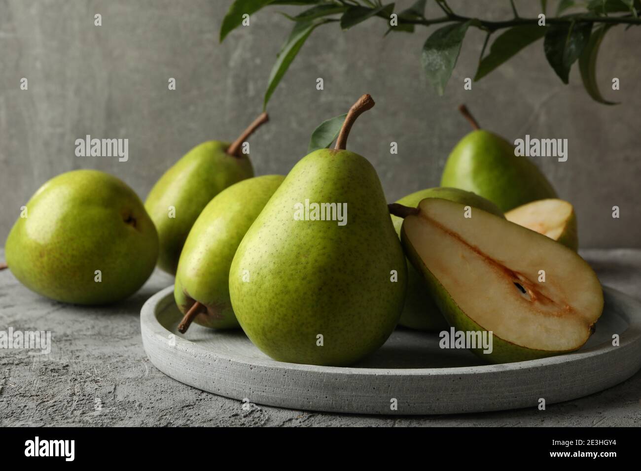 Tray with green pears on gray background Stock Photo - Alamy