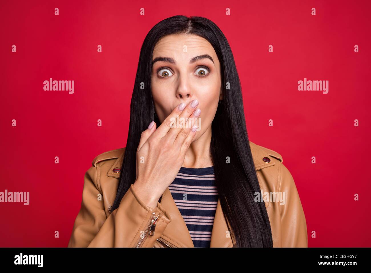 Portrait of pretty confused young woman hand covering mouth lips wear ...