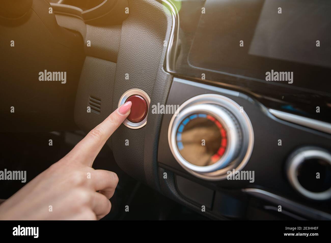 Woman's finger pressing the emergency lights button while driving ...