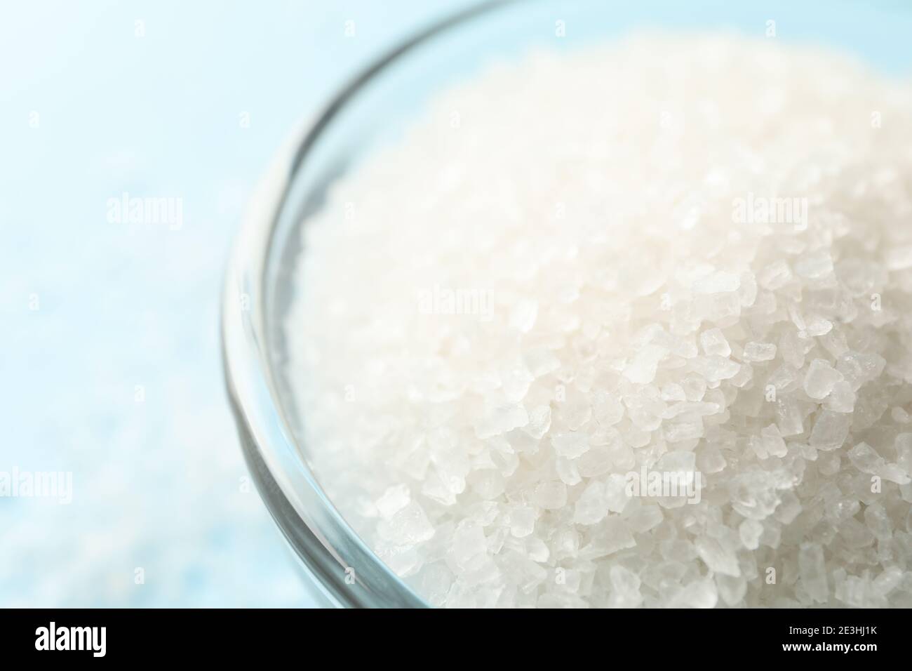 Glass bowl of salt on blue background Stock Photo - Alamy