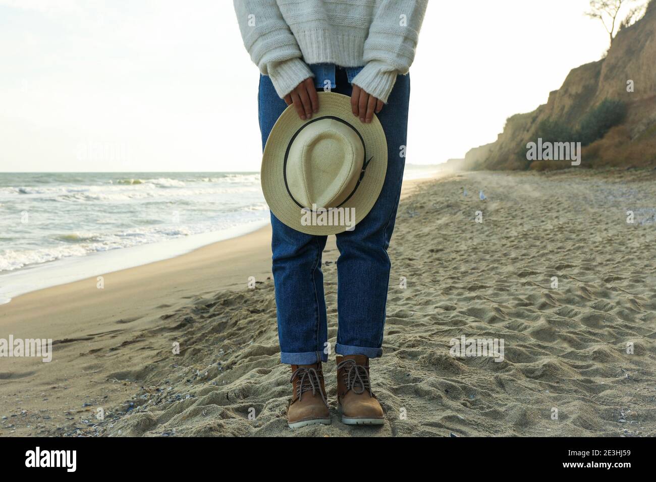 Handsome woman hold hat on sandy beach Stock Photo - Alamy