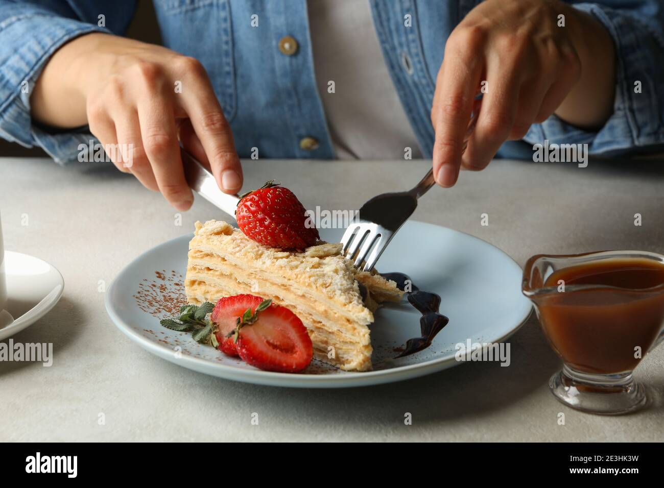 Woman eating delicious Napoleon cake, close up Stock Photo - Alamy