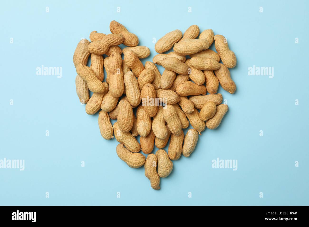 Heart made of peanut on blue background Stock Photo - Alamy