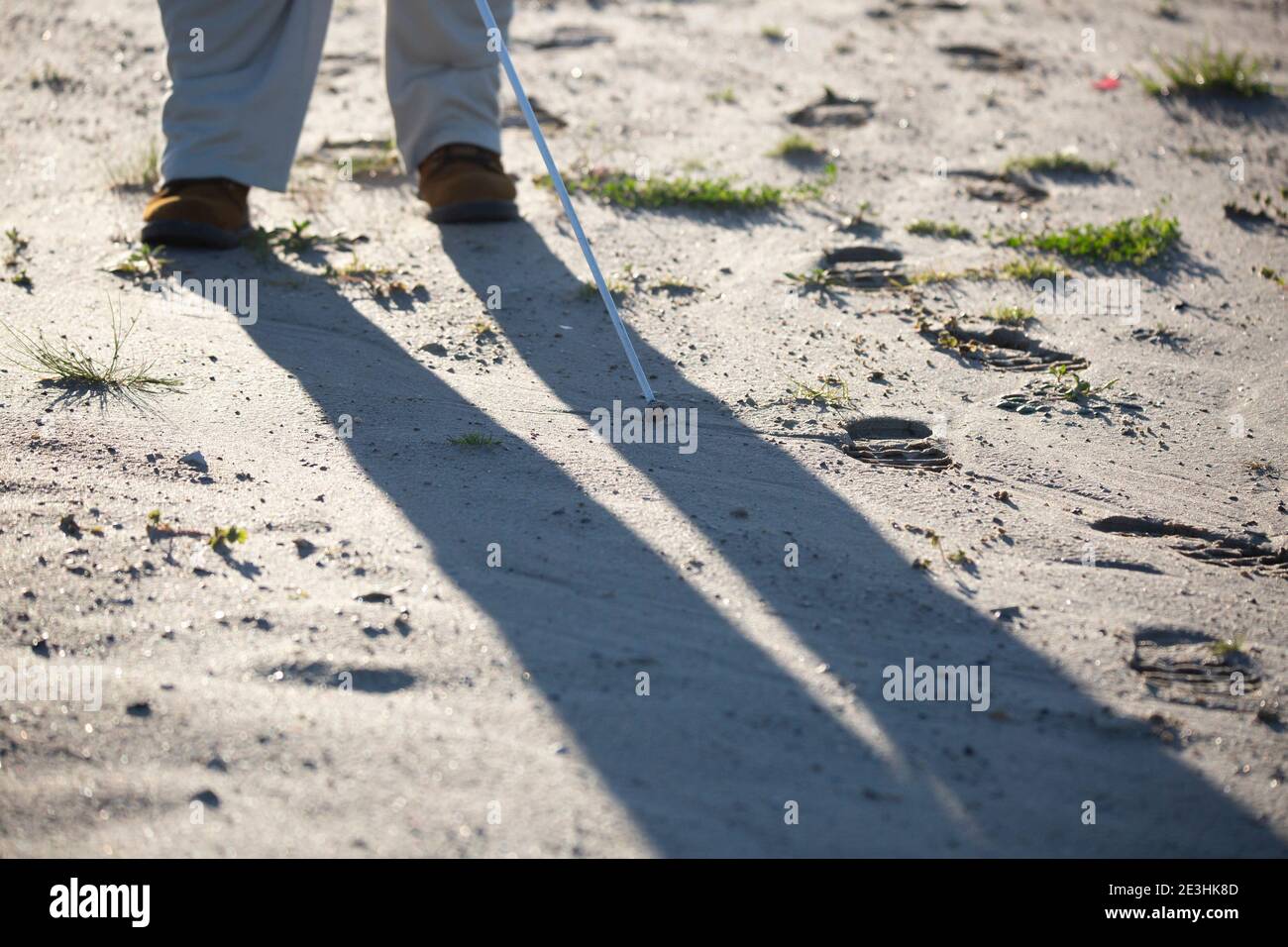 Close up of boots and a walking cane on a beach with tracks Stock Photo ...