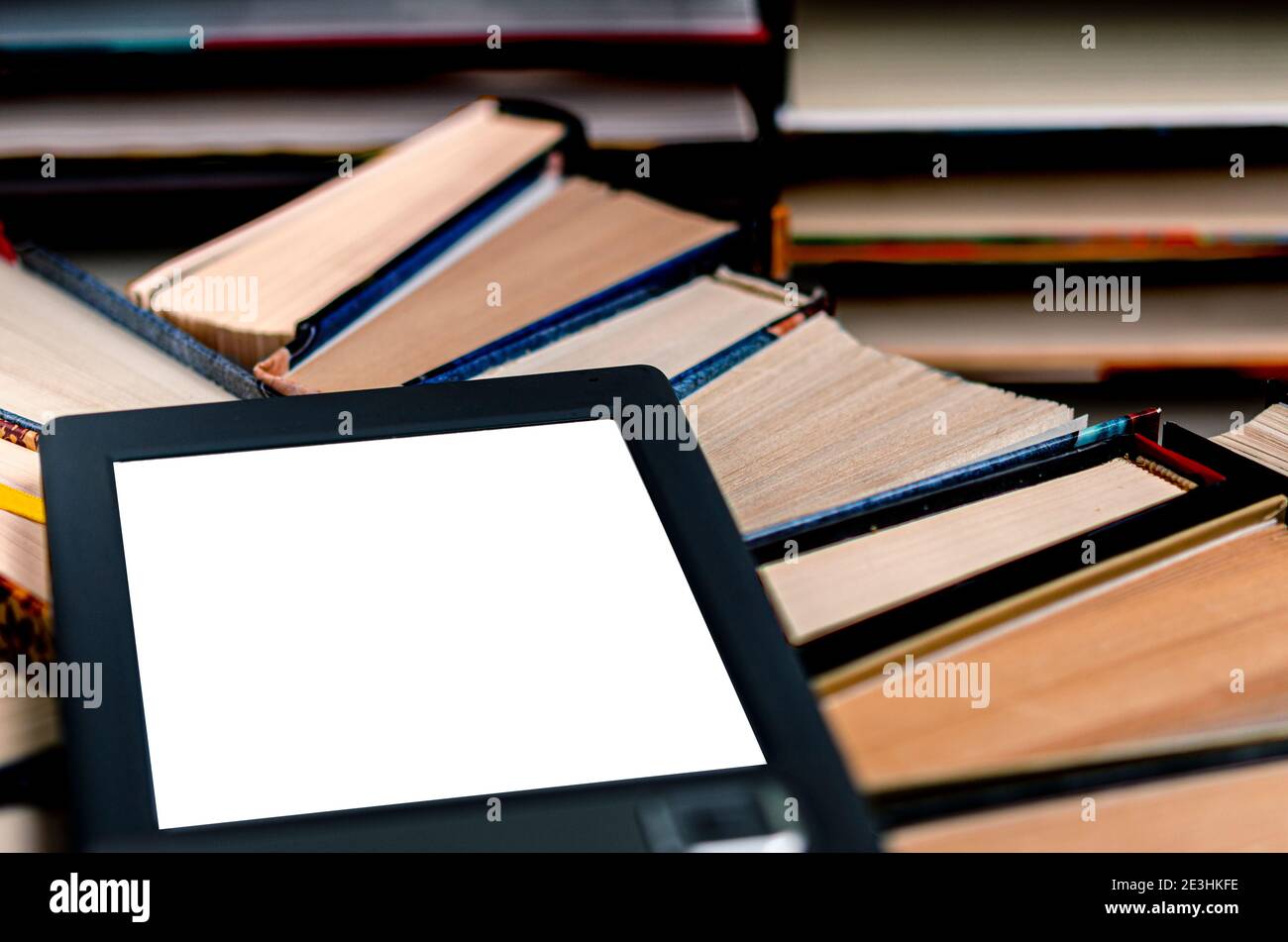 An e-book with a white screen and a place for text is on a shelf with ...