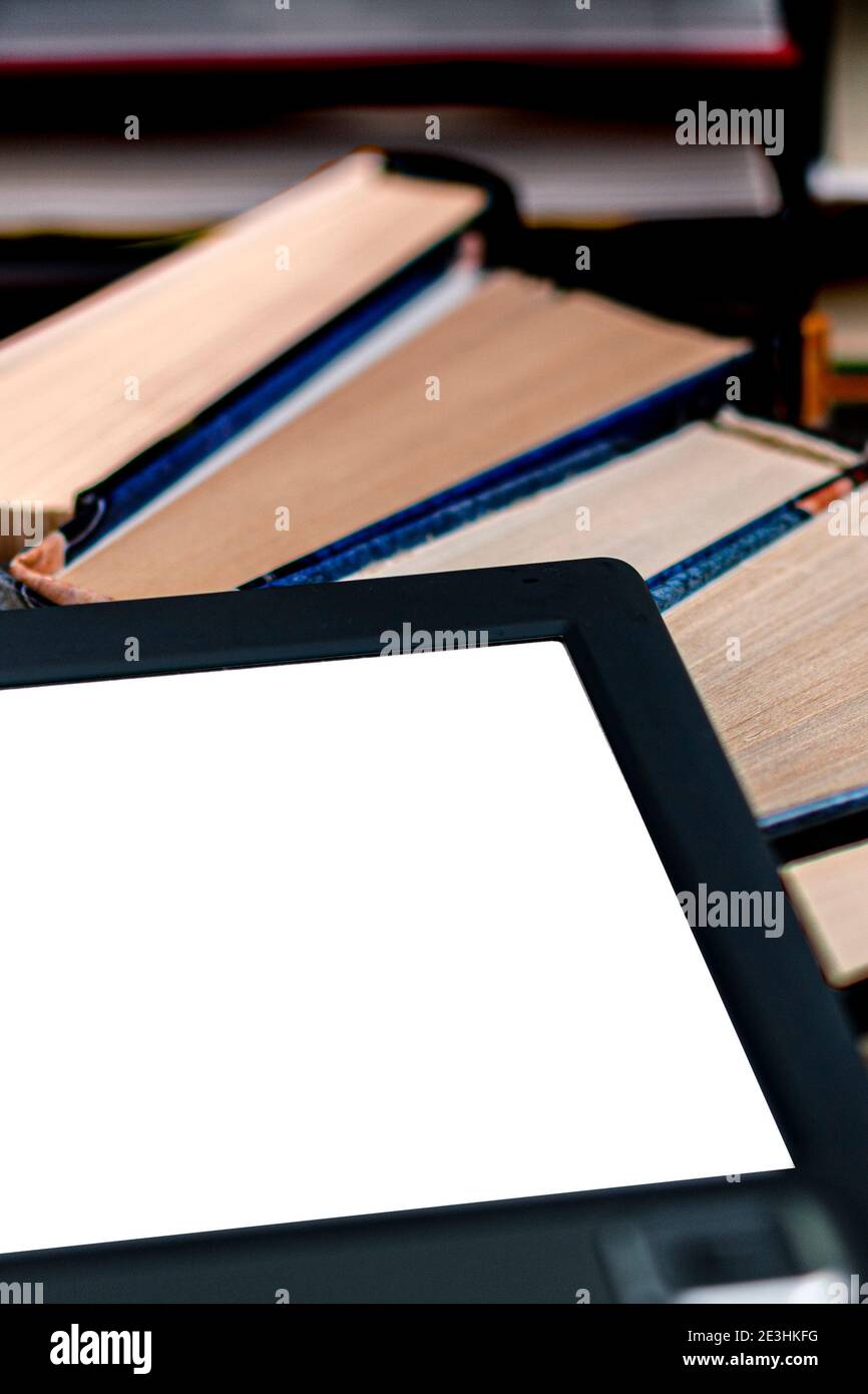 An e-book with a white screen and a place for text is on a shelf with ...