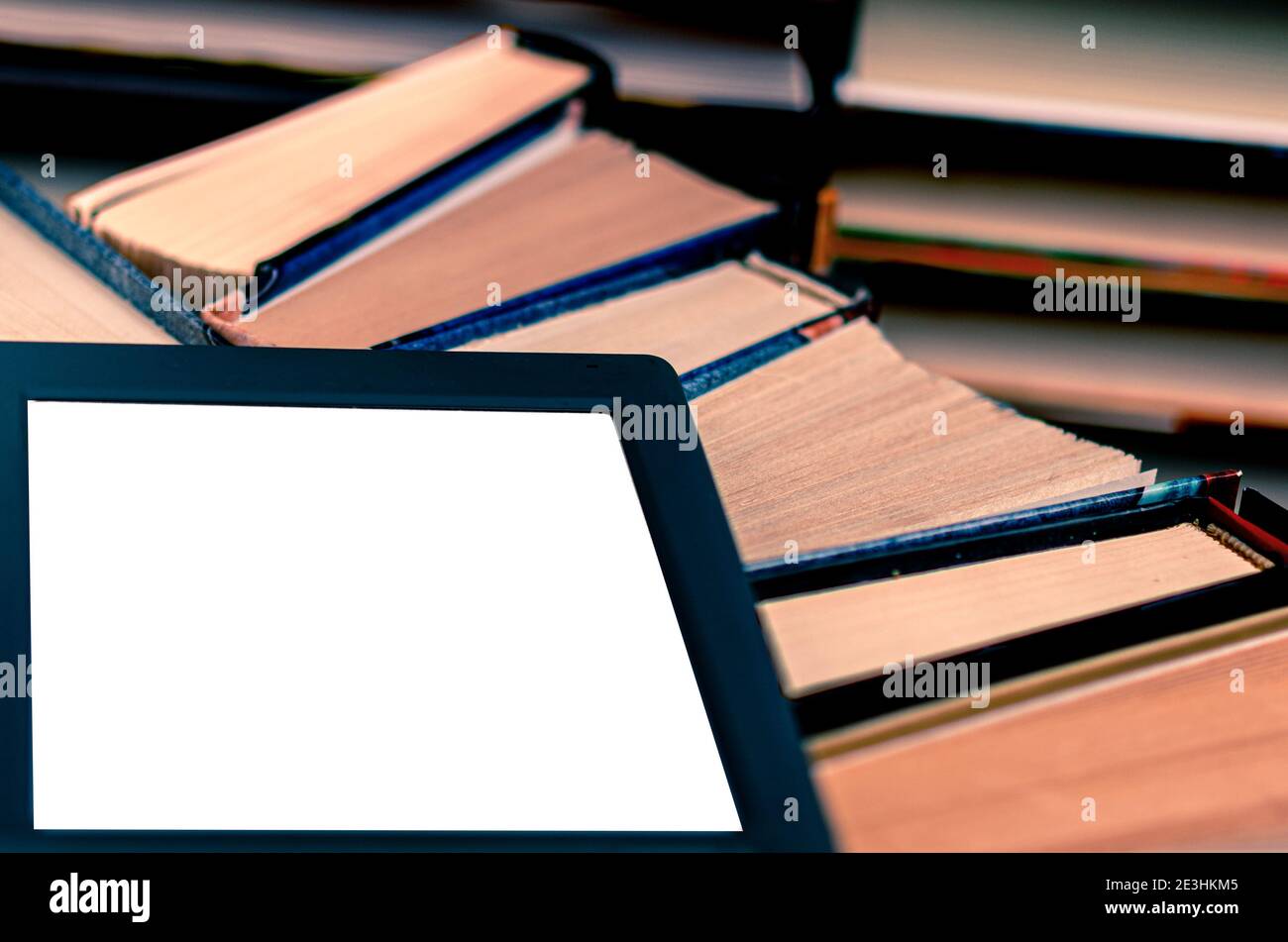 An e-book with a white screen and a place for text is on a shelf with ...